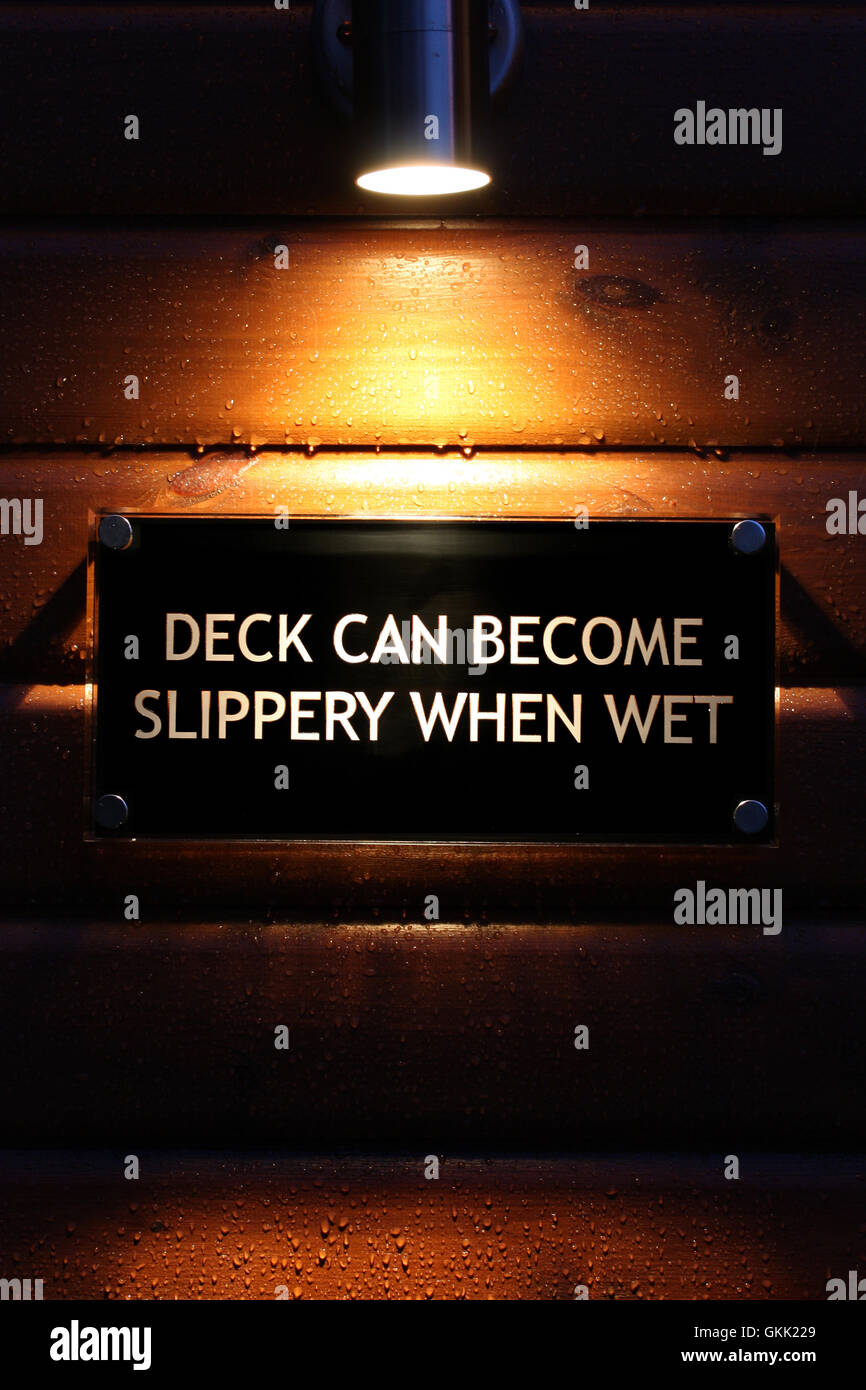 Lit warning sign on wet wood Stock Photo - Alamy