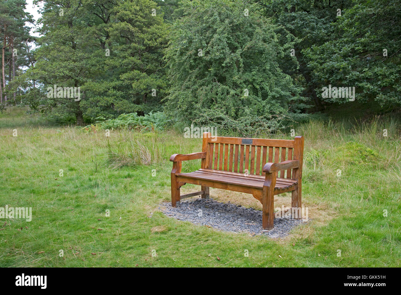 Hardwood commemorative three seater garden bench in countryside ...