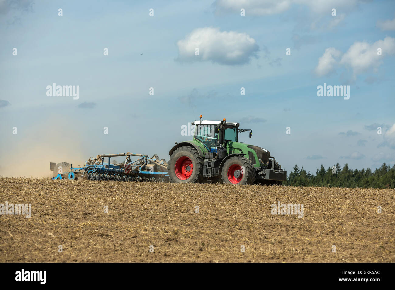 Green Tractor with cultivator handles field before planting Stock Photo ...
