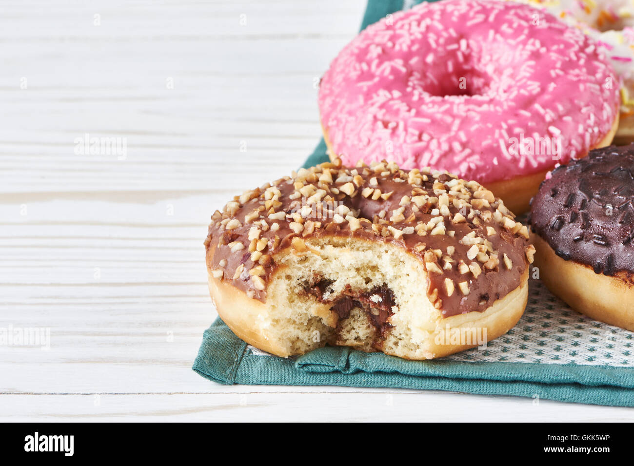 Colored donuts on white wooden background Stock Photo - Alamy