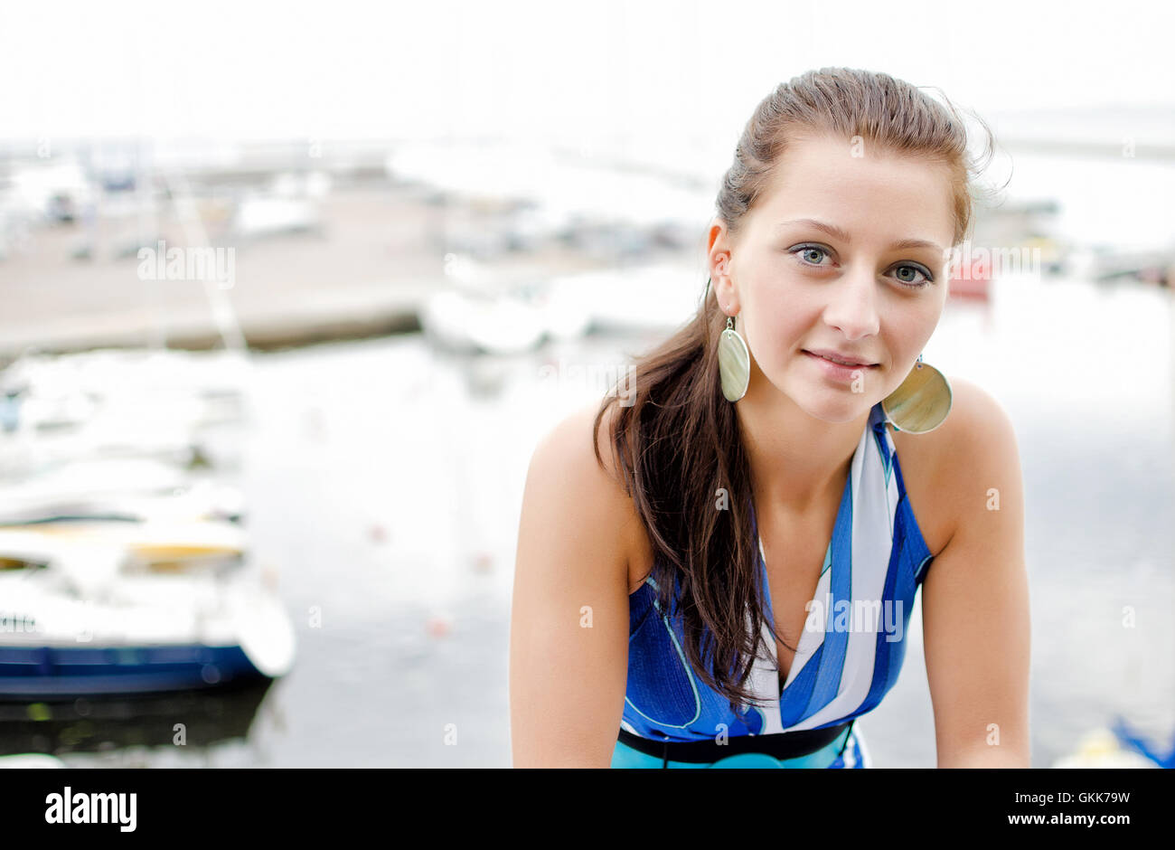 Pretty girl portrait, against of the pier with yachts Stock Photo - Alamy