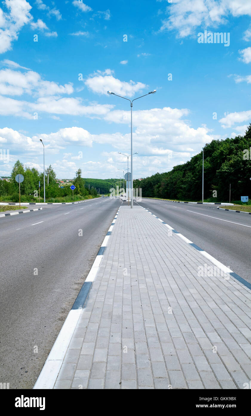 asphalt road with a divider for pedestrians Stock Photo - Alamy