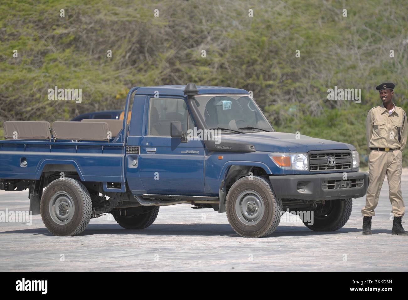 A Somali National Police officer stands in front of a Land Cruiser ...