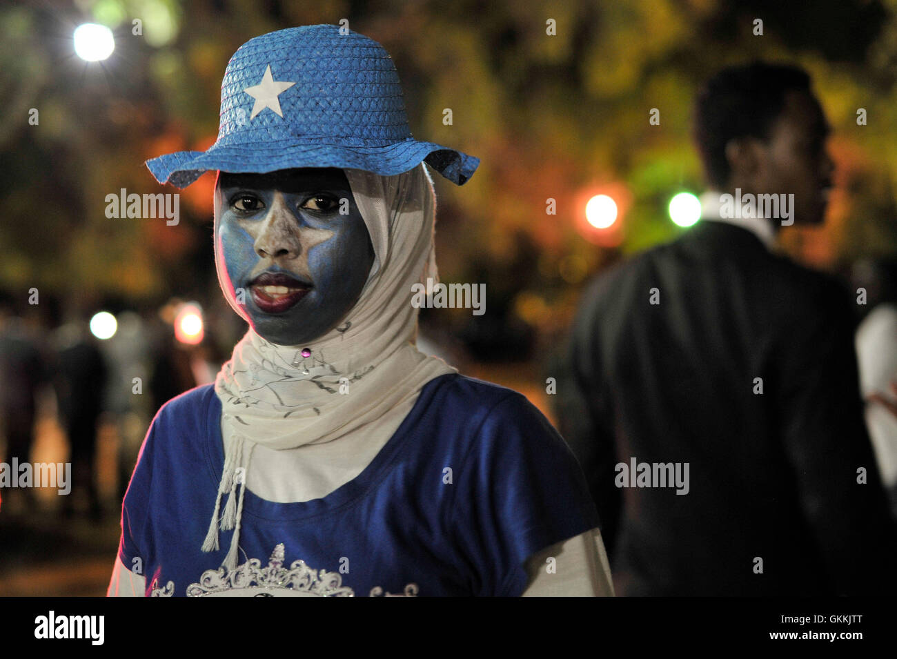 A young Somali woman, with her face painted in the national flag’s ...