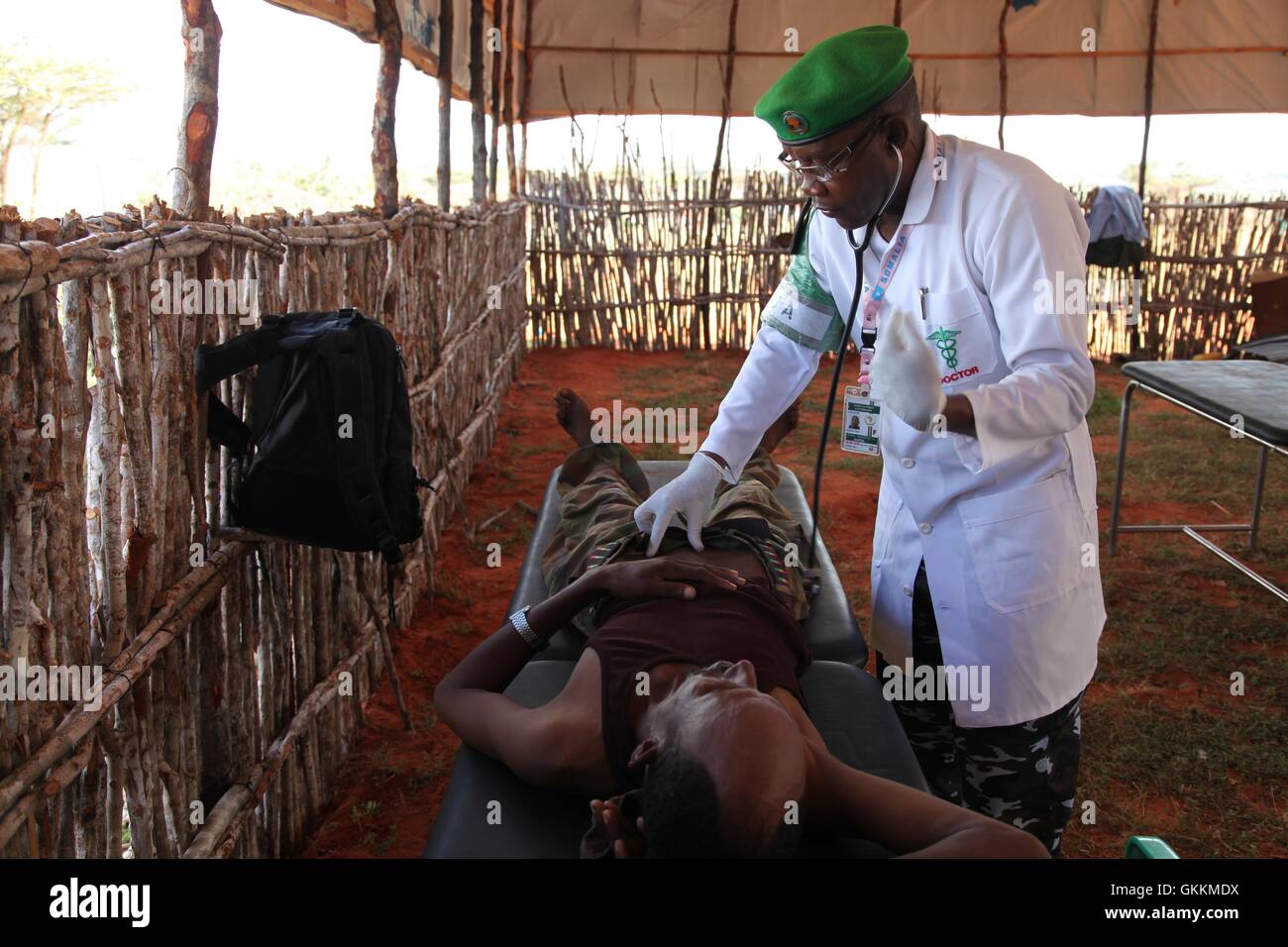 An AMISOM Police Officer conducts a medical check-up for a new recruit ...