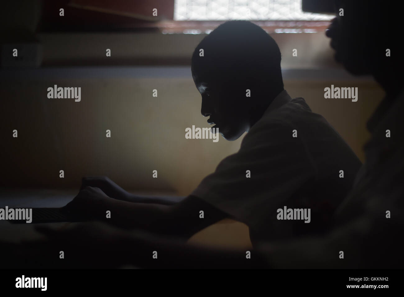 A child with impaired eyesight practices braille writing at the Al-Nor ...