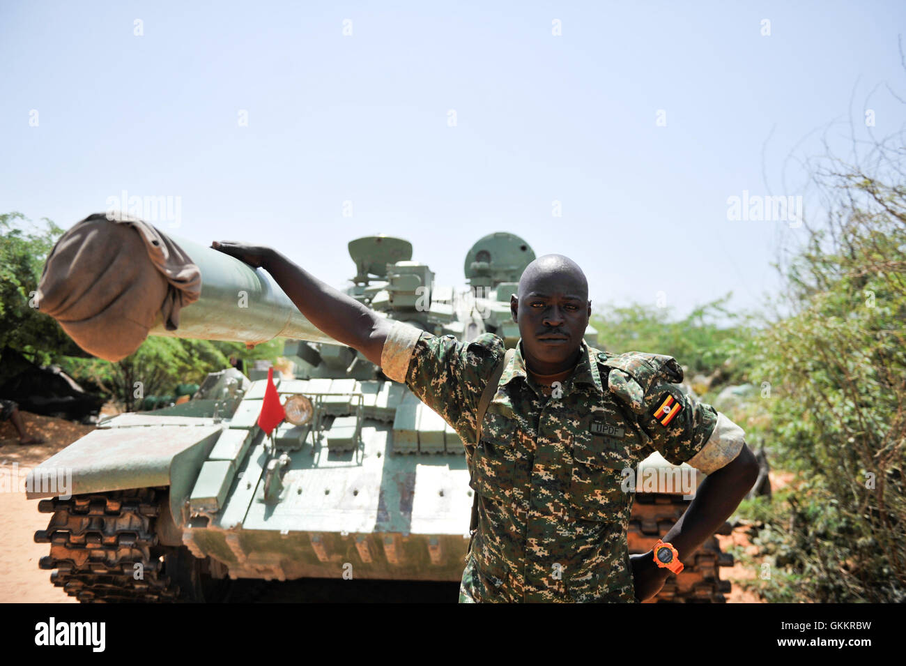 A Ugandan soldier in AMISOM stands in front of a battle tank in Marka ...