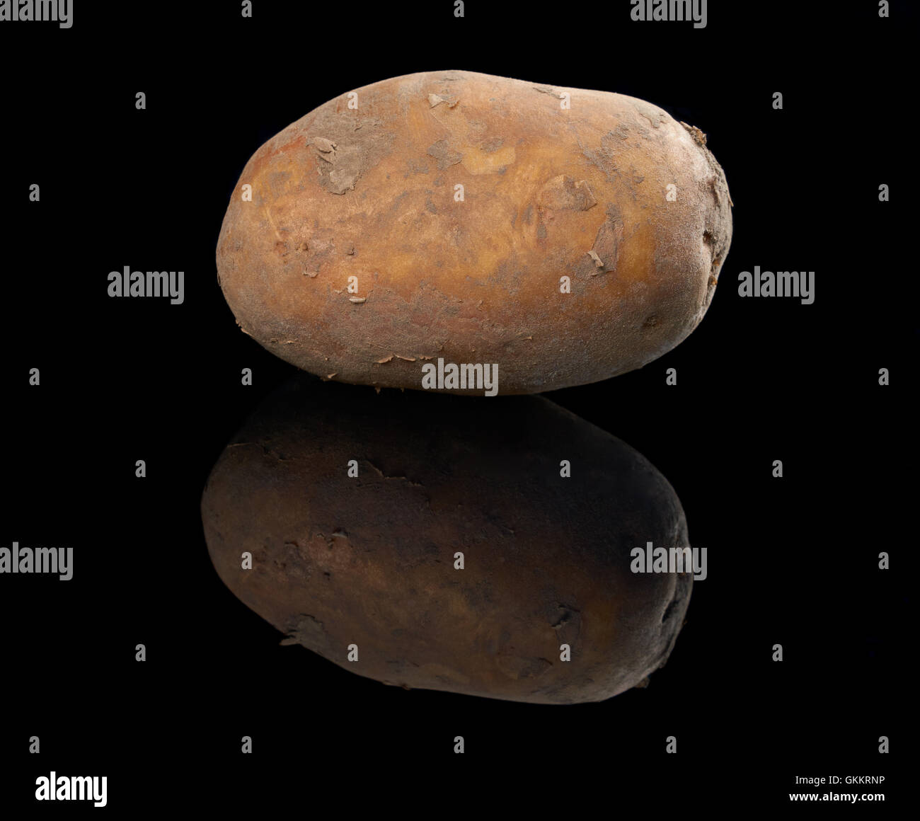 One potato isolated on black reflecting background Stock Photo - Alamy