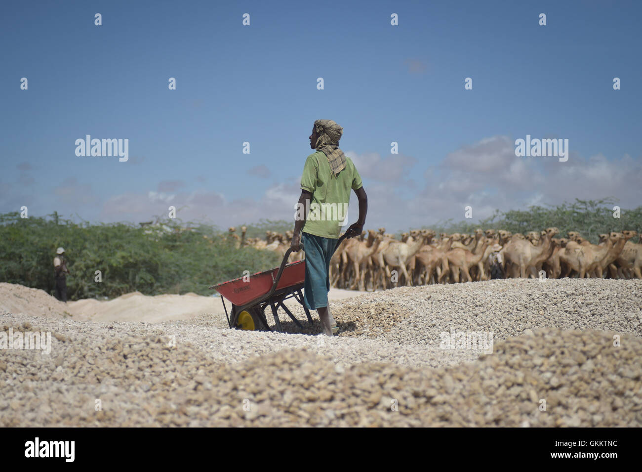 A quarry worker moves gravel in a small quarry in Mogadishu, with ...
