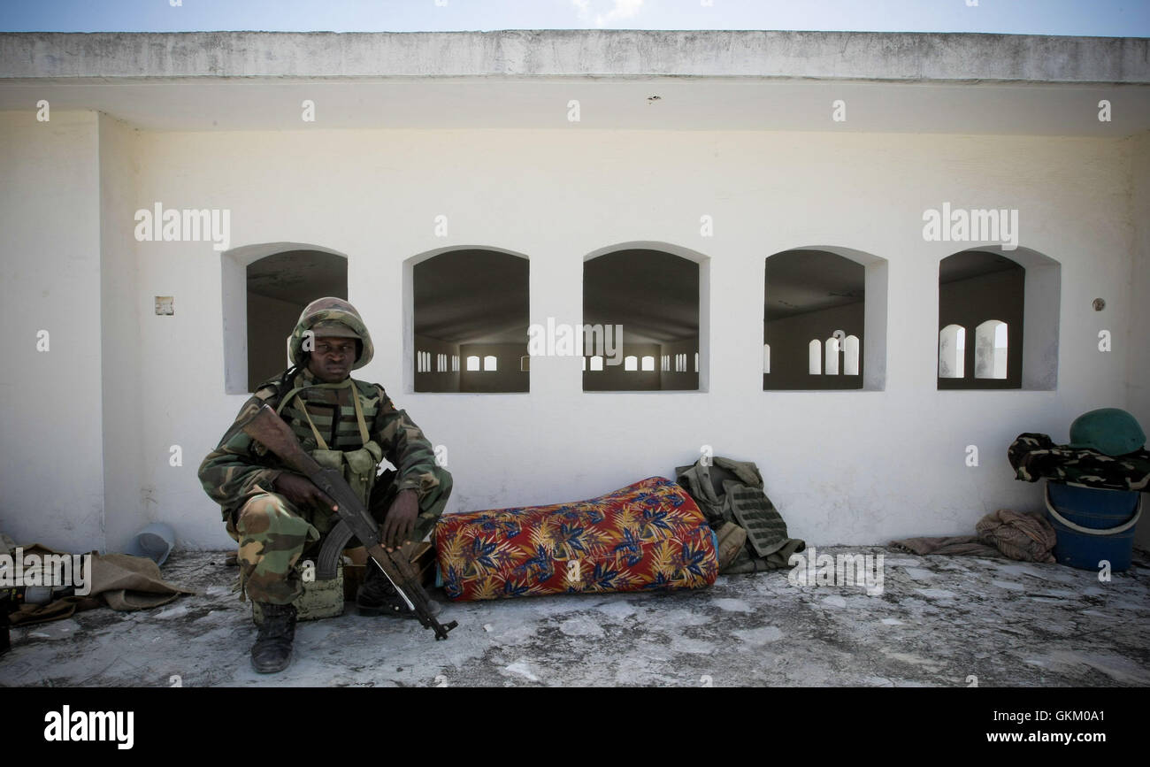 A Ugandan soldier from AMISOM sits in a defensive position on the roof ...