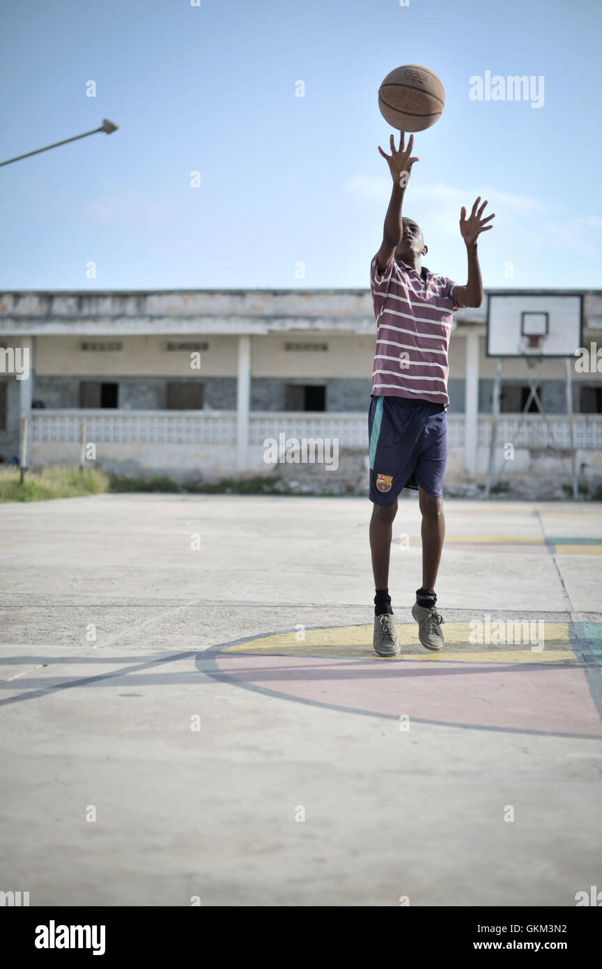 On June 6, a boy practices his shot on a basketball court in Mogadishu ...