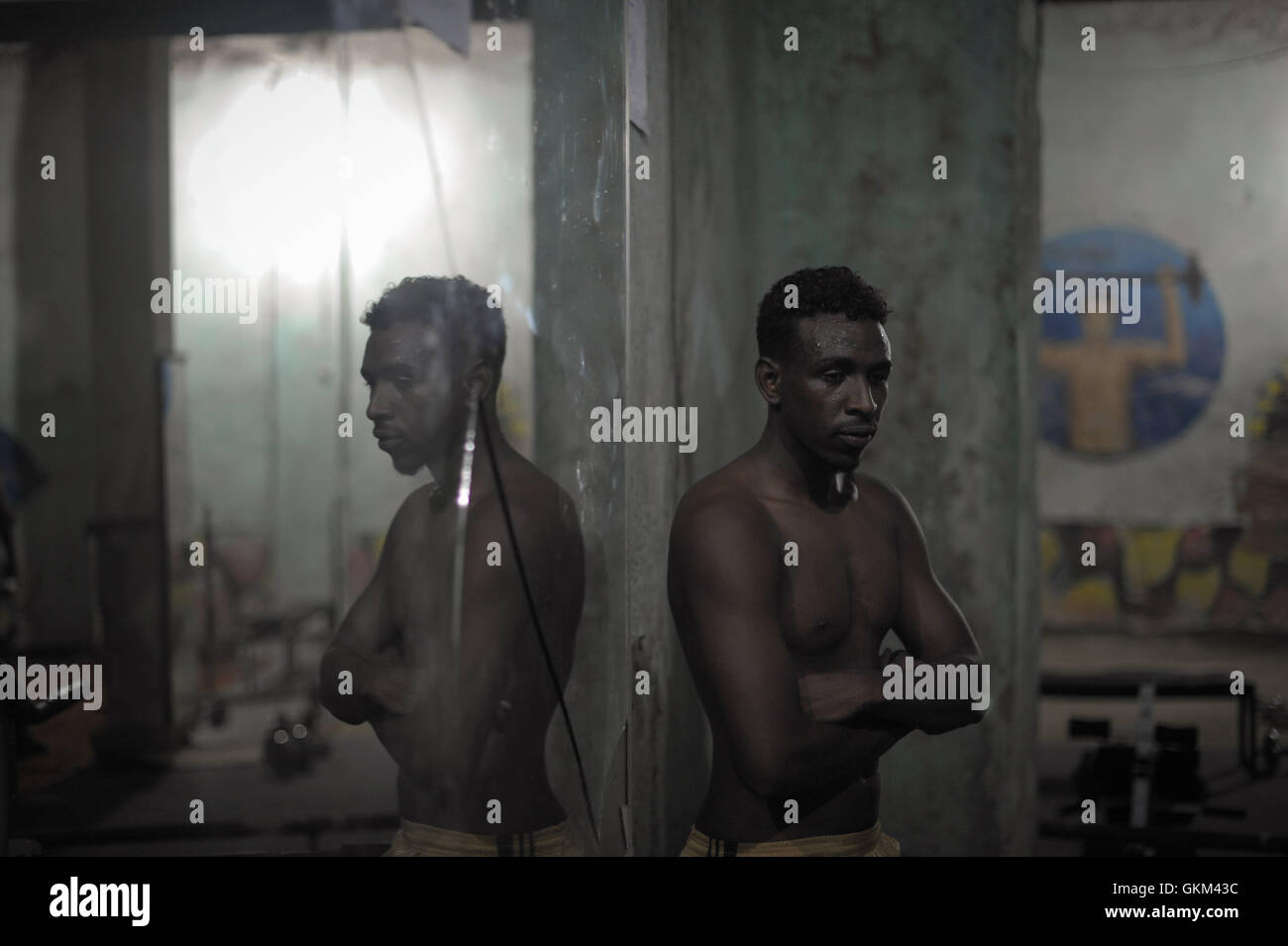 On August 12, a weight lifter takes a break during training at a gym in ...