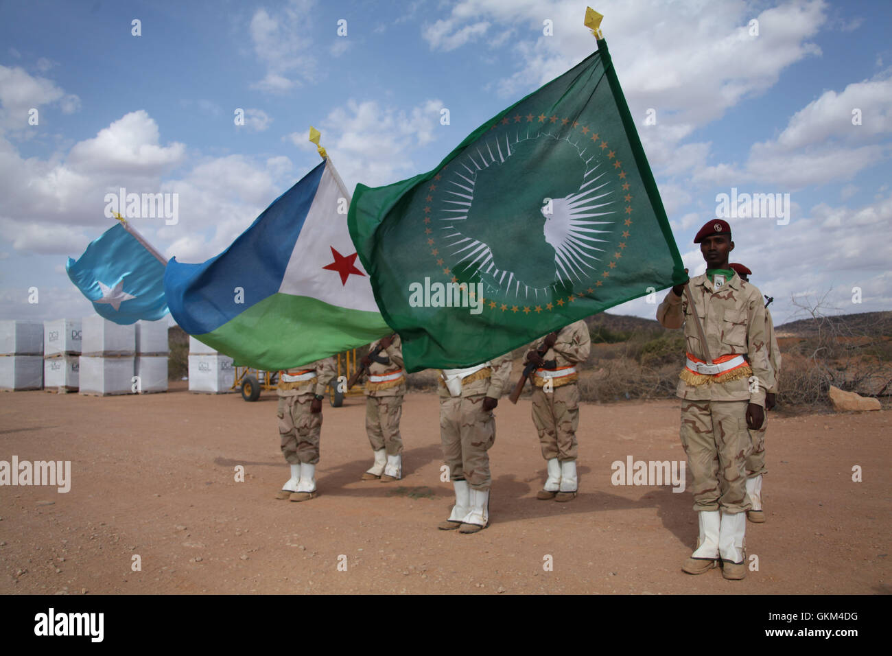 Djiboutian soldiers, carrying the flags of AMISOM, Djibouti, and ...