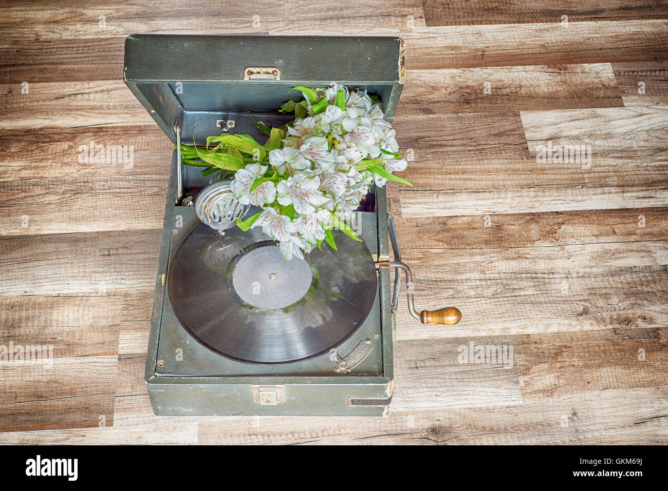 Vintage turntable vinyl record player and withered flowers on wooden ...
