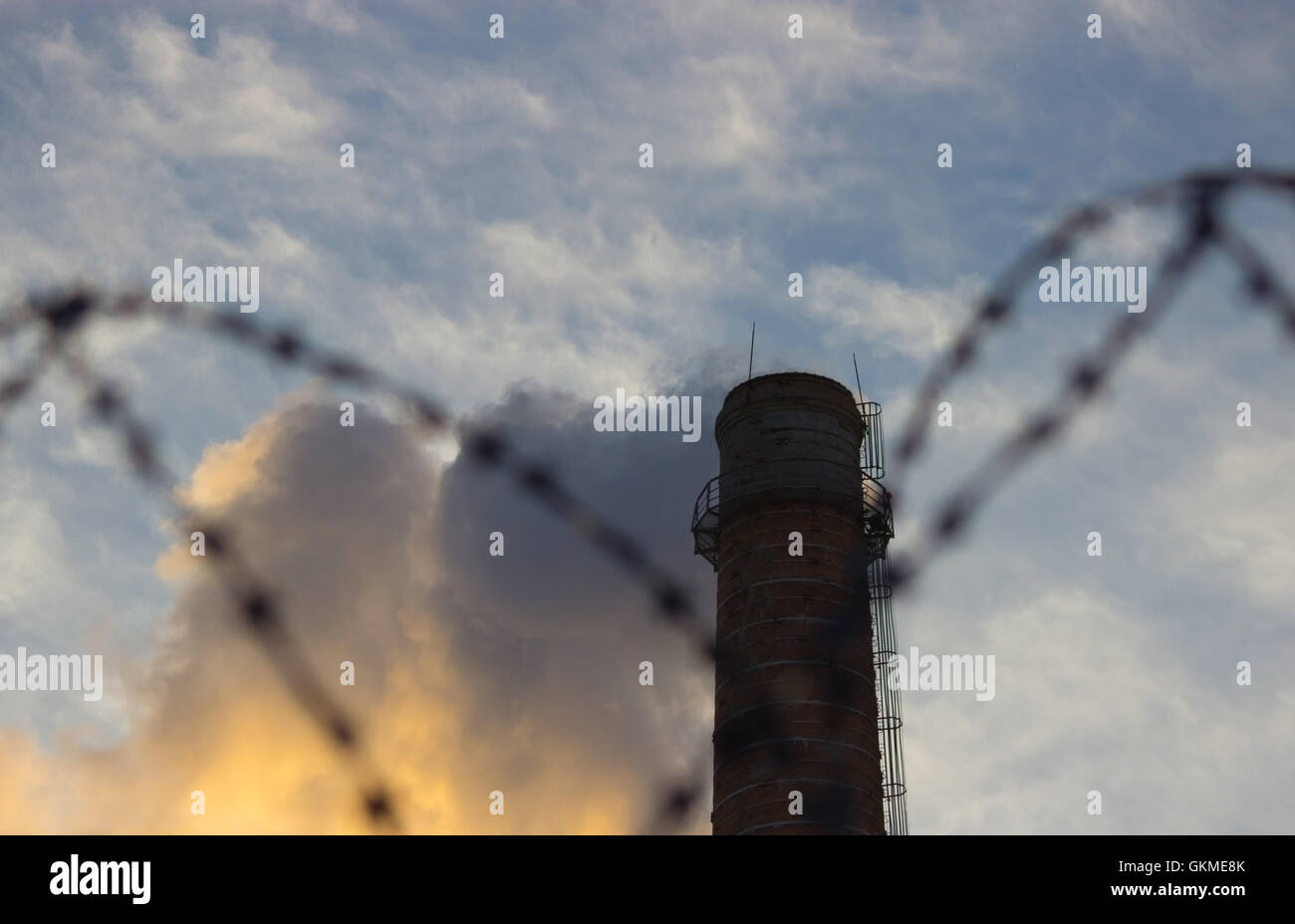 Barbed wire on a background of factory pipe Stock Photo - Alamy