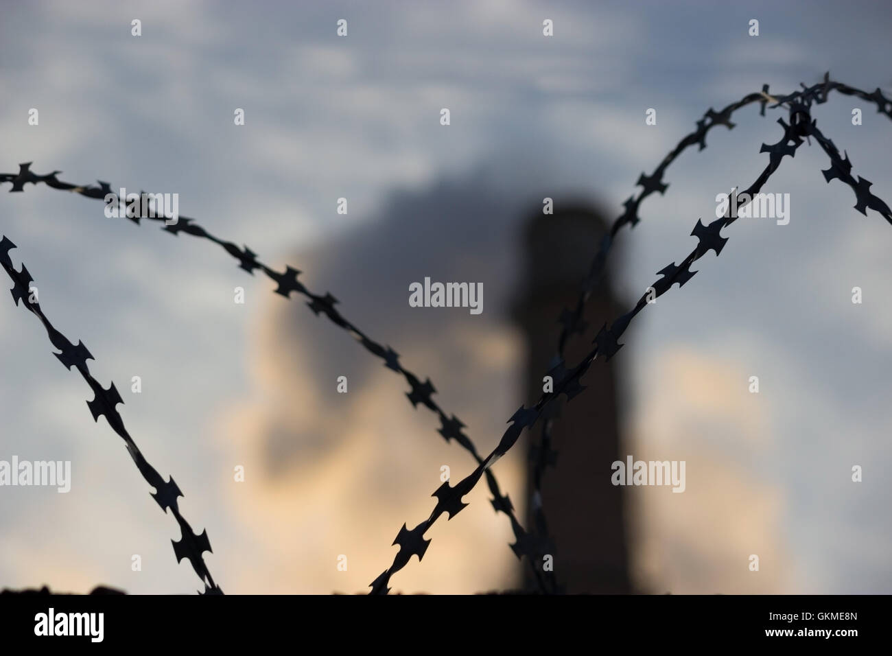 Barbed wire on a background of factory pipe Stock Photo - Alamy