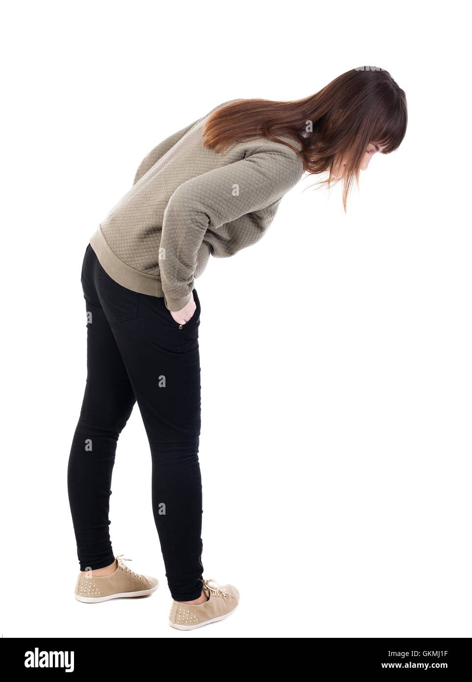back view of standing young beautiful woman in jeans looks down. girl ...
