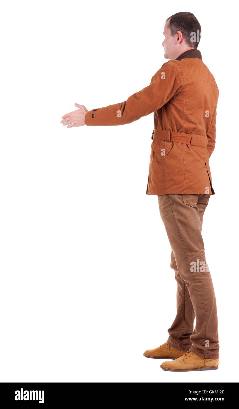 back view of businessman in movement reaches out to shake hands. Rear ...