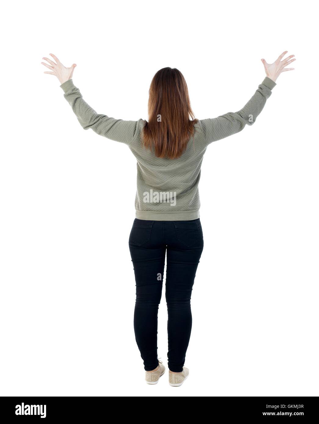 Back view of Beautiful woman looking at wall and Holds hand up. young ...