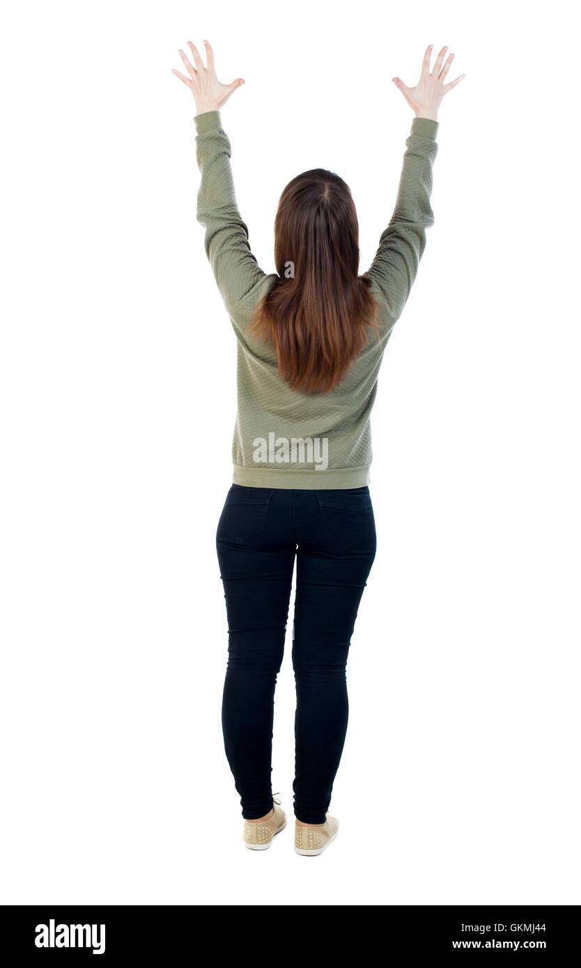 Back view of Beautiful woman looking at wall and Holds hand up. young ...