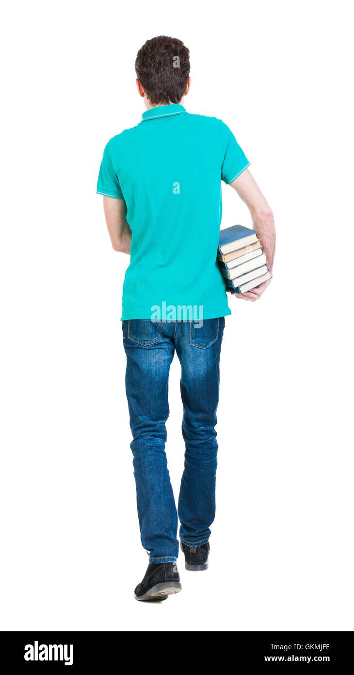 Back view of going handsome man carries a stack of books Stock Photo ...