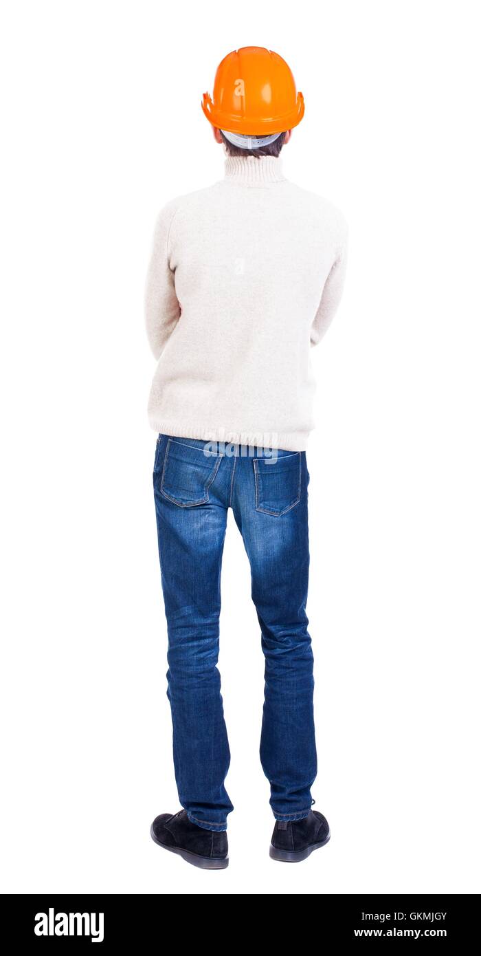 Backview of an engineer in construction helmet stands. Standing young ...