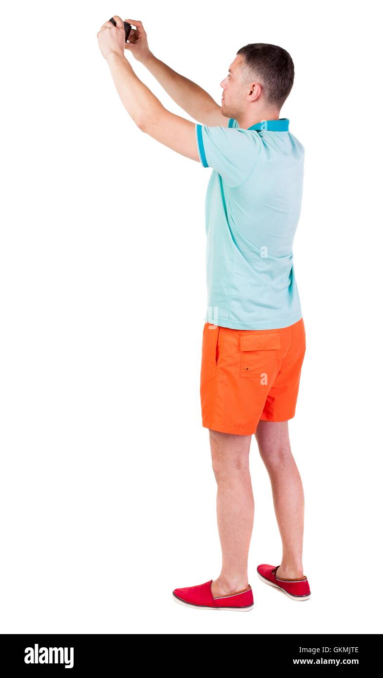 Back view of man photographing. tourist in shorts. Rear view people ...