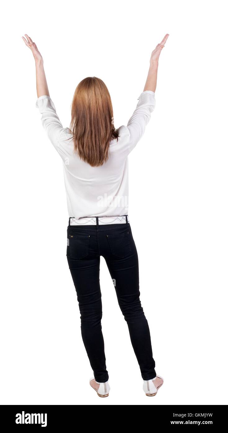 Back view of Beautiful woman in jeans looking at wall and Holds hand up ...