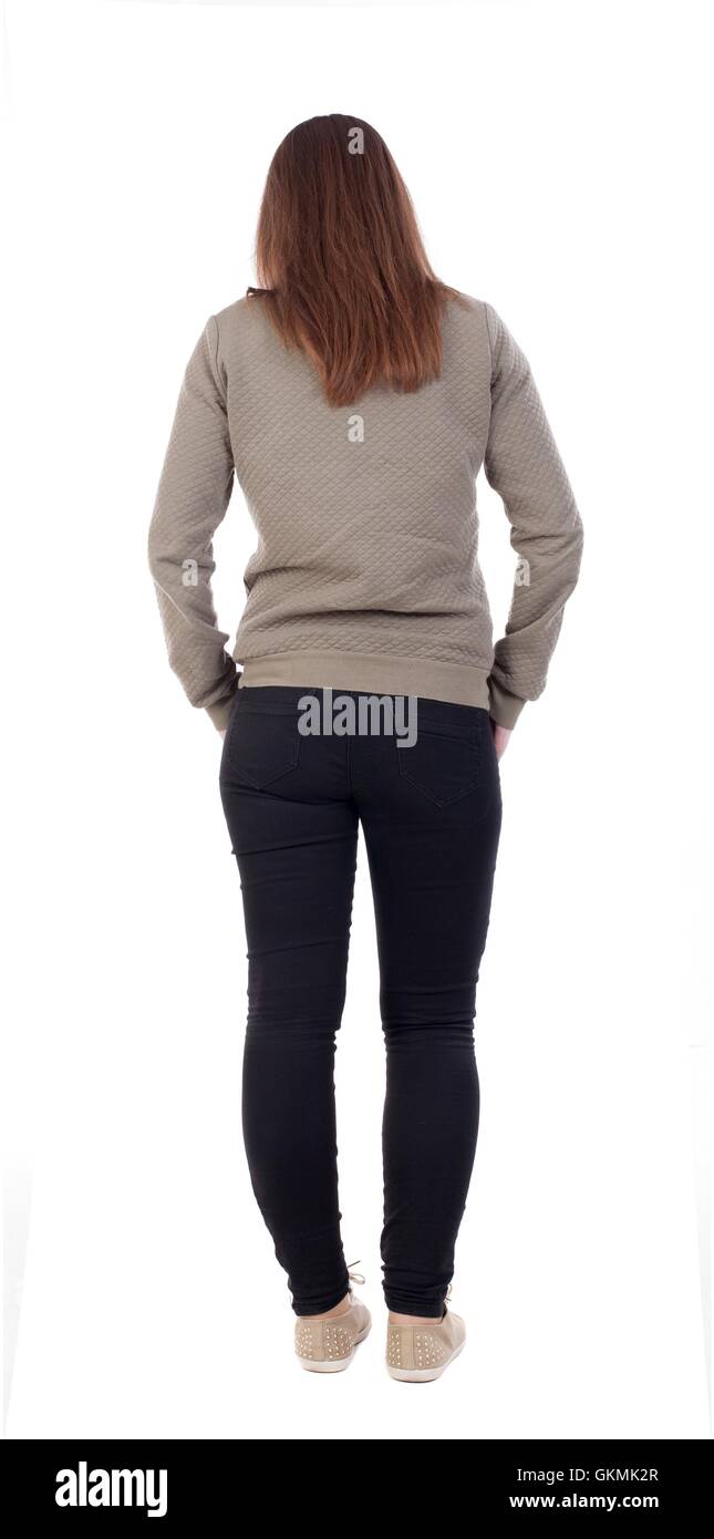 back view of standing young beautiful woman in jeans. girl watching ...