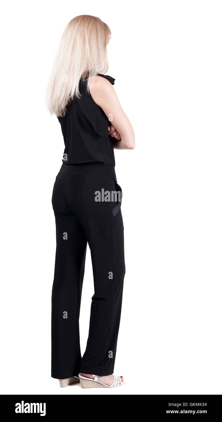 back view of standing young beautiful blonde woman. she shyly looks at ...