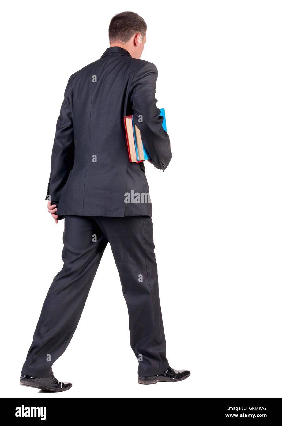 back view of walking business man with books. going young guy in black ...
