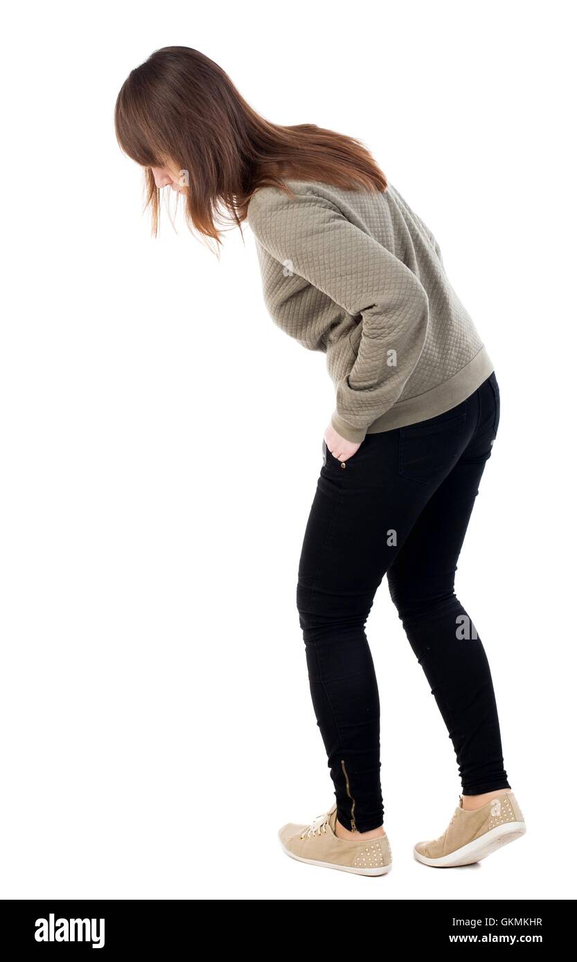 back view of standing young beautiful woman in jeans looks down. girl ...