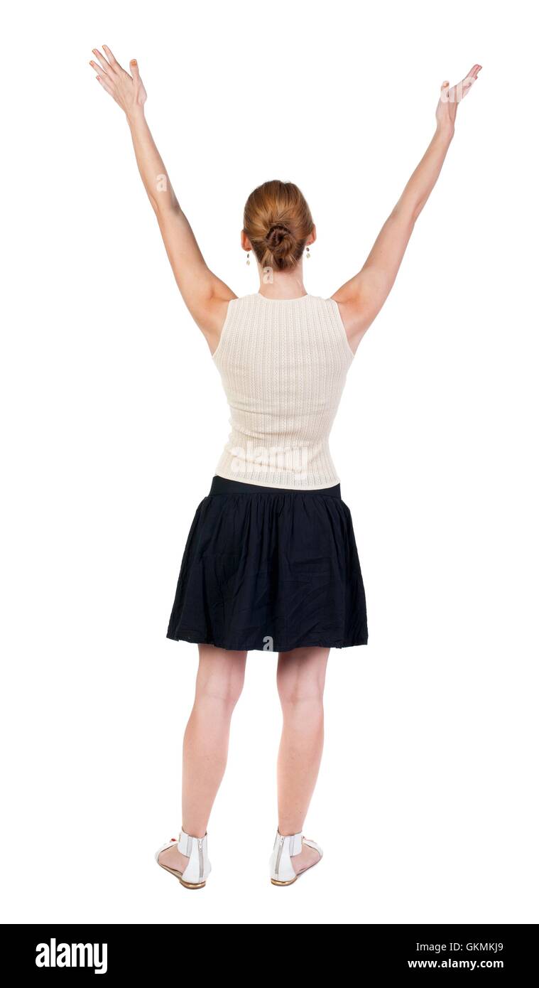 Back view of Beautiful woman in dress looking at wall and Holds hand up ...
