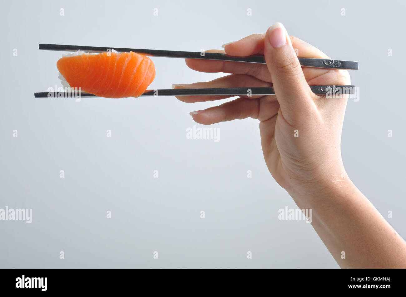 hand holding sushi using chopstick Stock Photo - Alamy