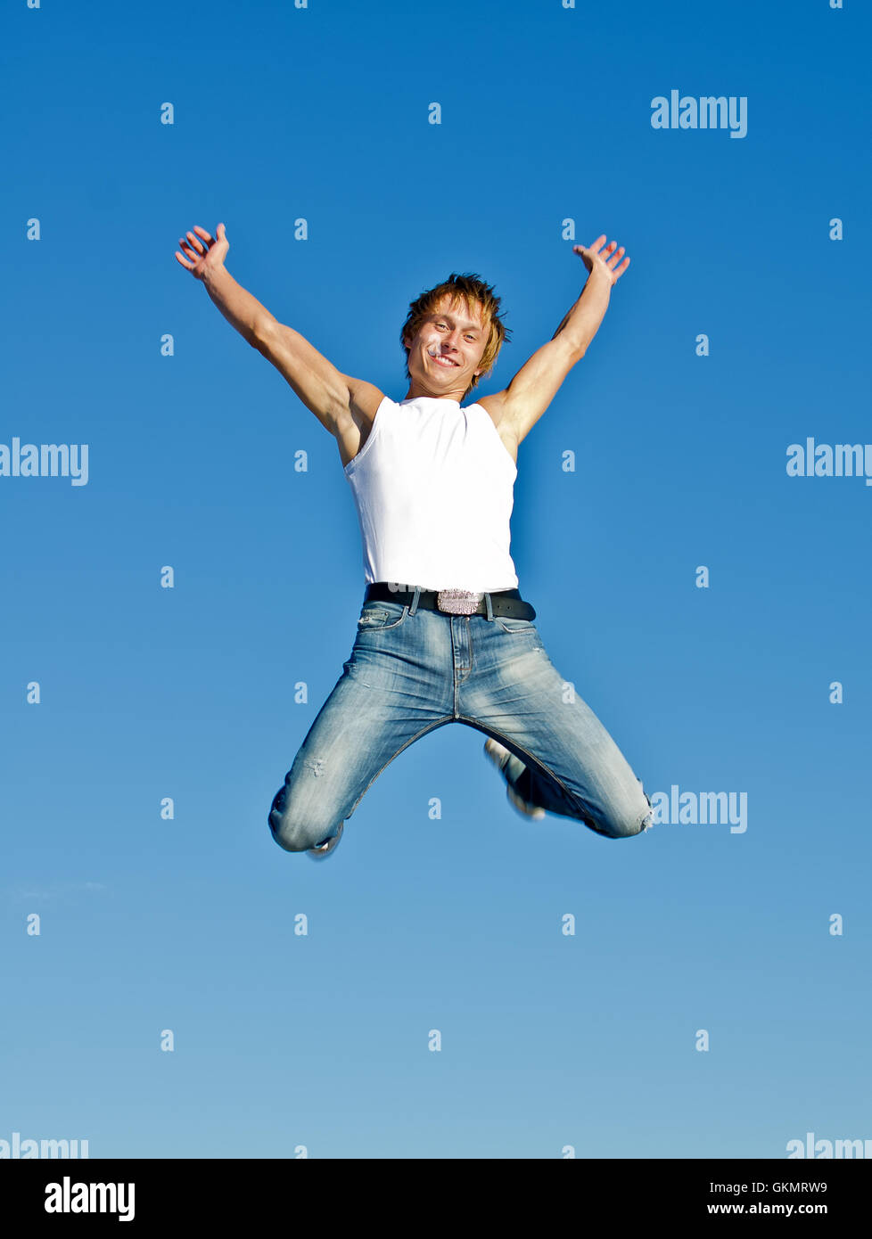 Happy jumping man on blue sky background Stock Photo - Alamy