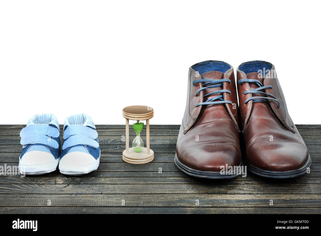 Grow up concept with kid shoes and business shoes on wooden floor Stock ...