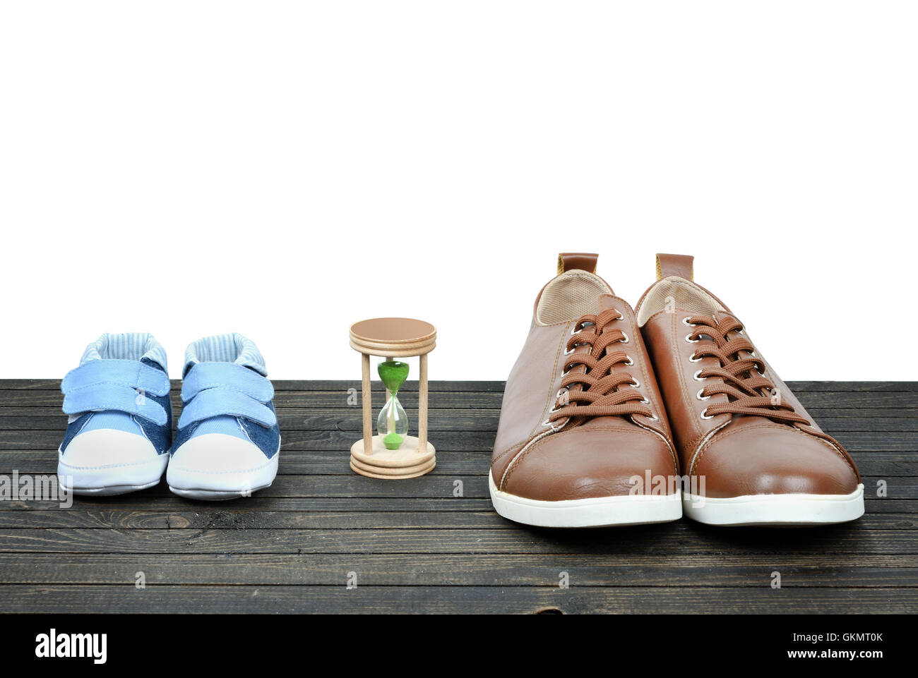 Grow up concept with kid shoes and business shoes on wooden floor Stock ...