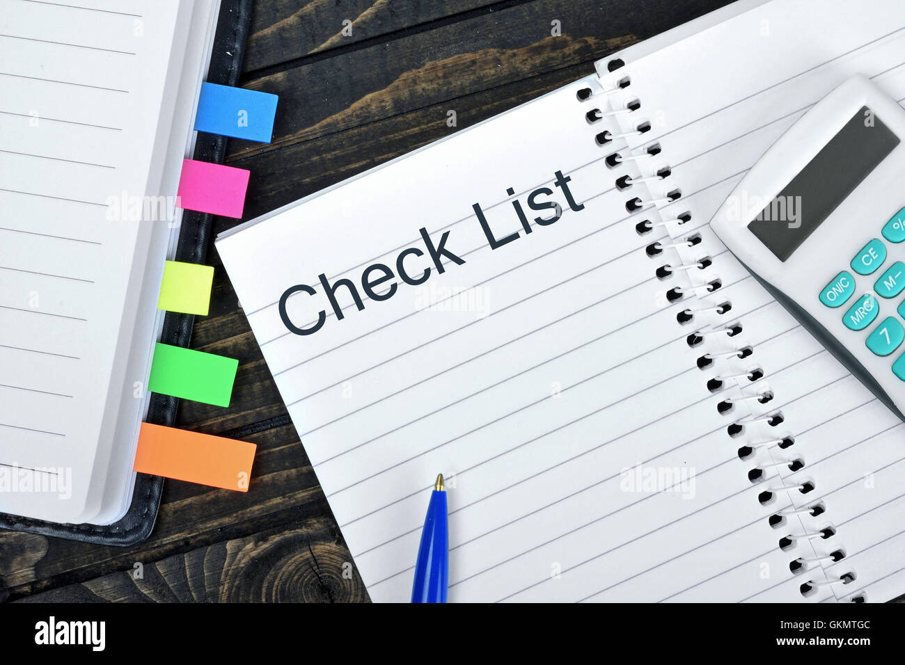 Check List text on notepad and hand calculator Stock Photo - Alamy