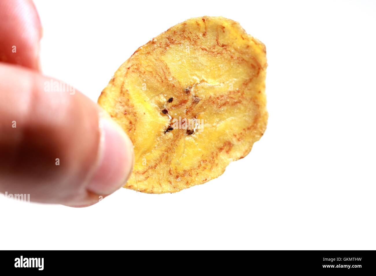 banana chip in hand Stock Photo - Alamy