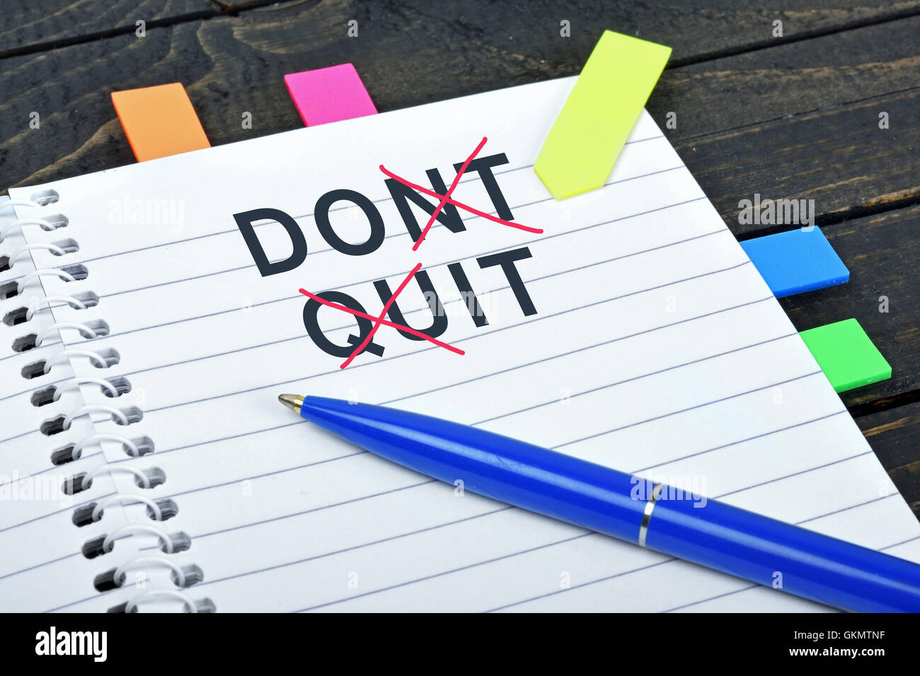 Don't quit word on notepad and pen Stock Photo - Alamy