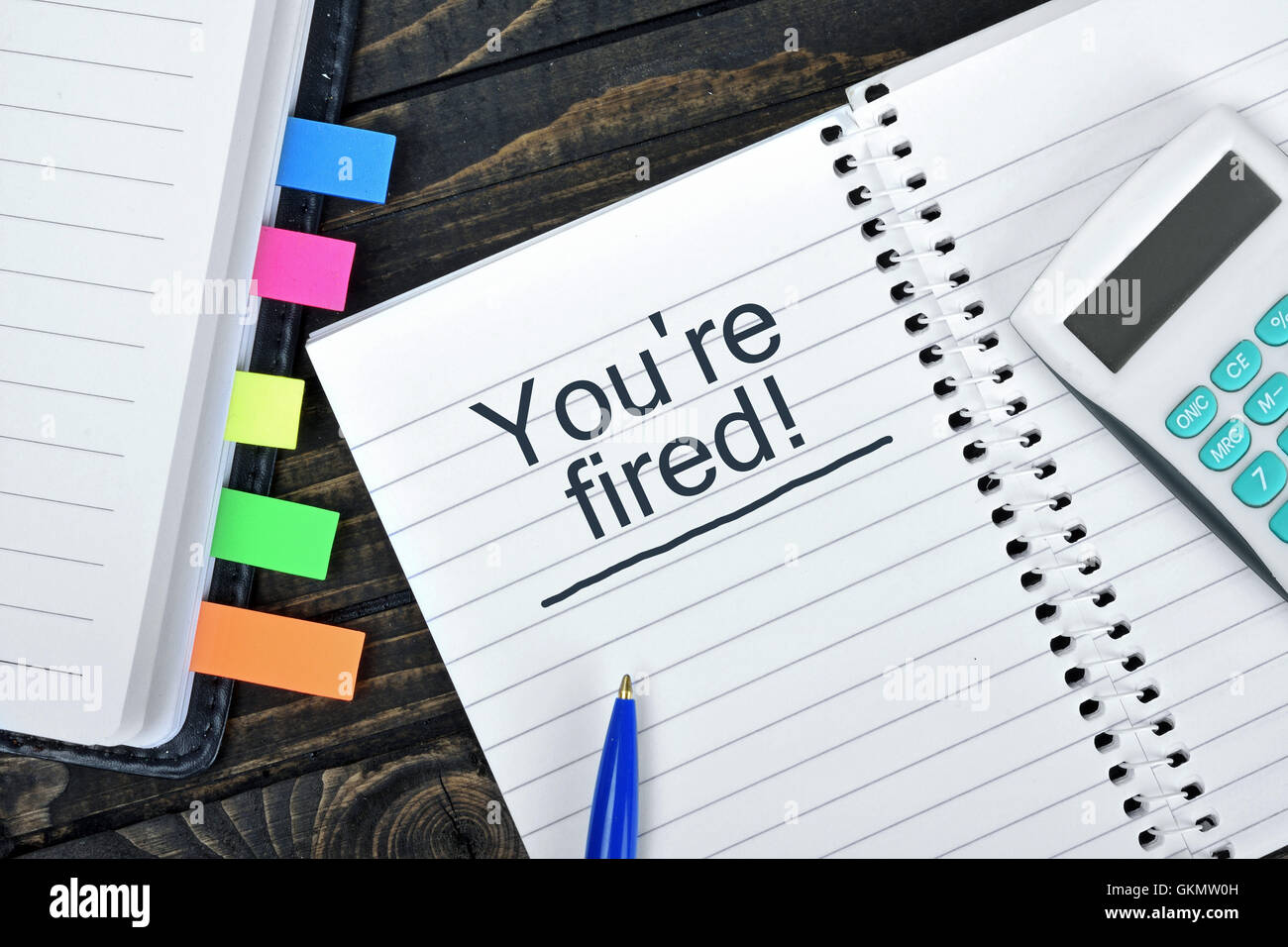 You're fired text on notepad and hand calculator Stock Photo - Alamy
