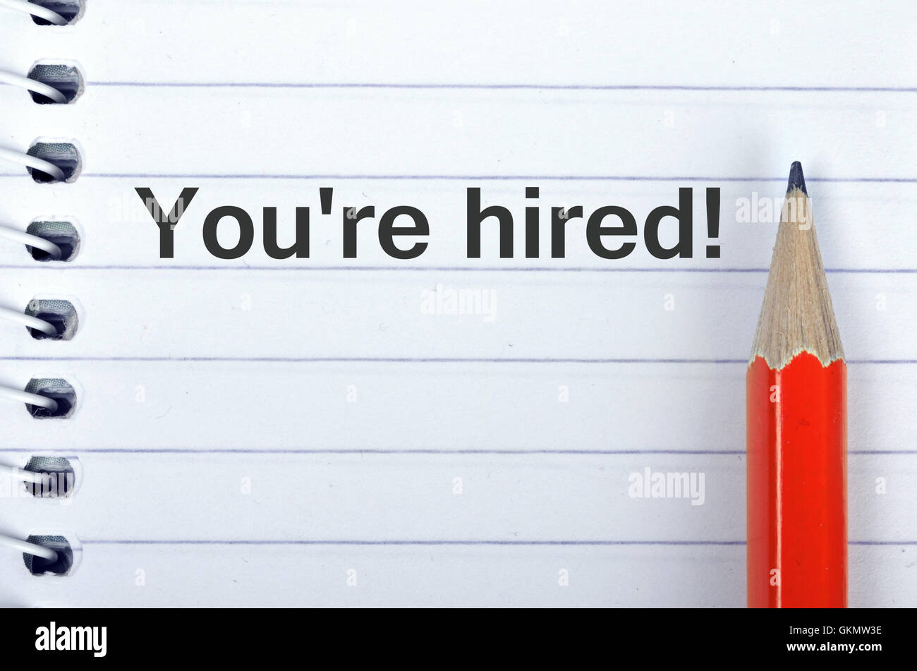 You're hired text on notepad and red pencil Stock Photo - Alamy