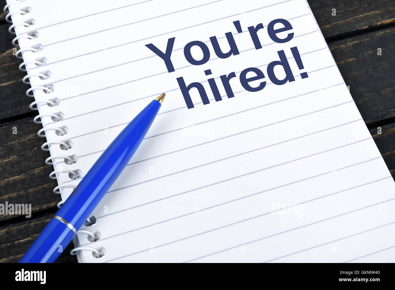 You're hired text on notepad and blue pen Stock Photo - Alamy