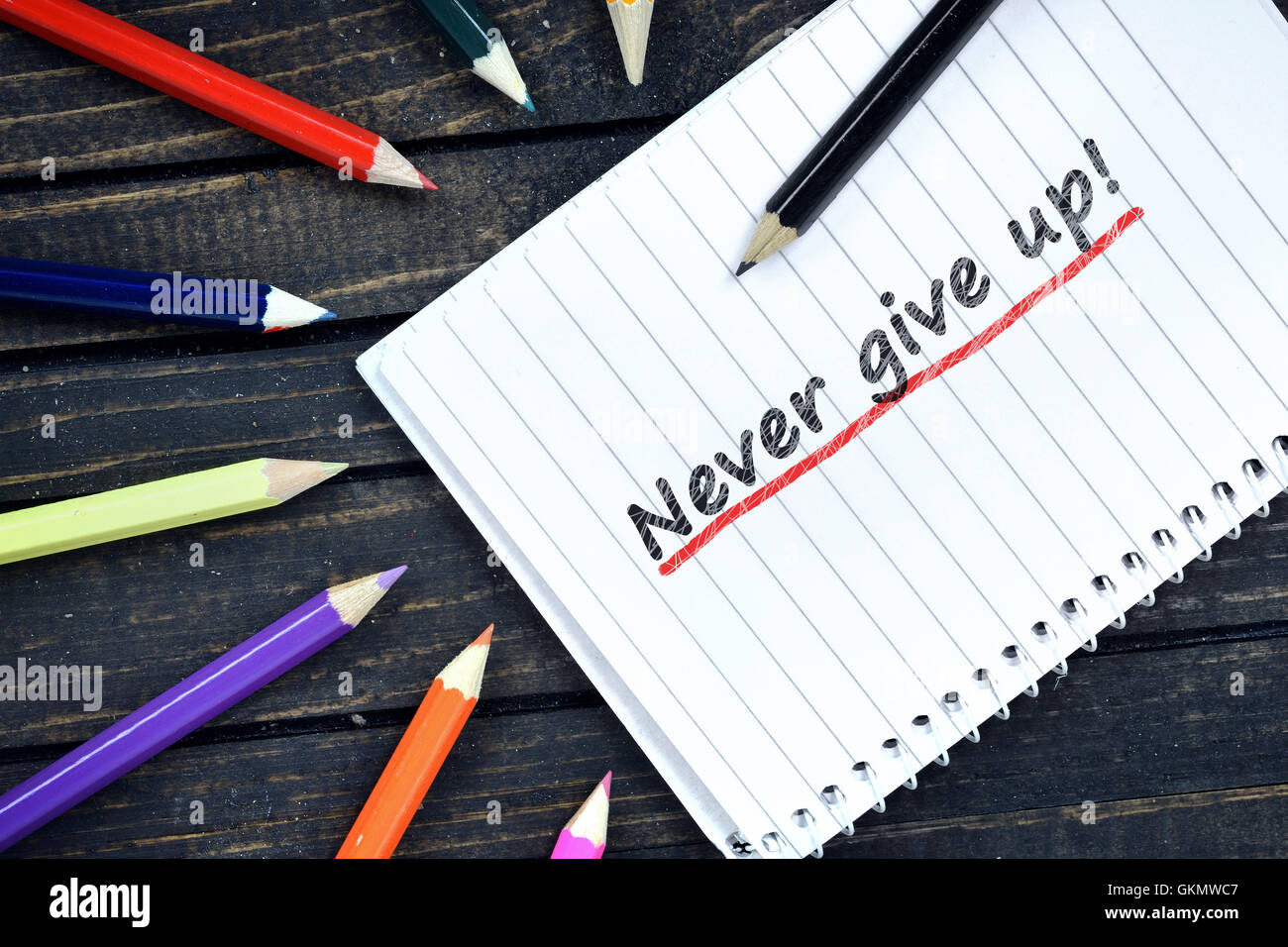 Never give up text on notepad and colorful pencils Stock Photo - Alamy