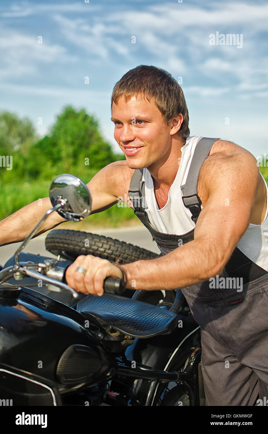 Portrait of handsome mechanic pushing a motorcycle Stock Photo - Alamy