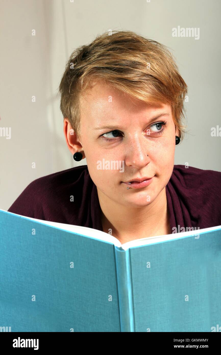 critically looking girl is reading a book Stock Photo - Alamy