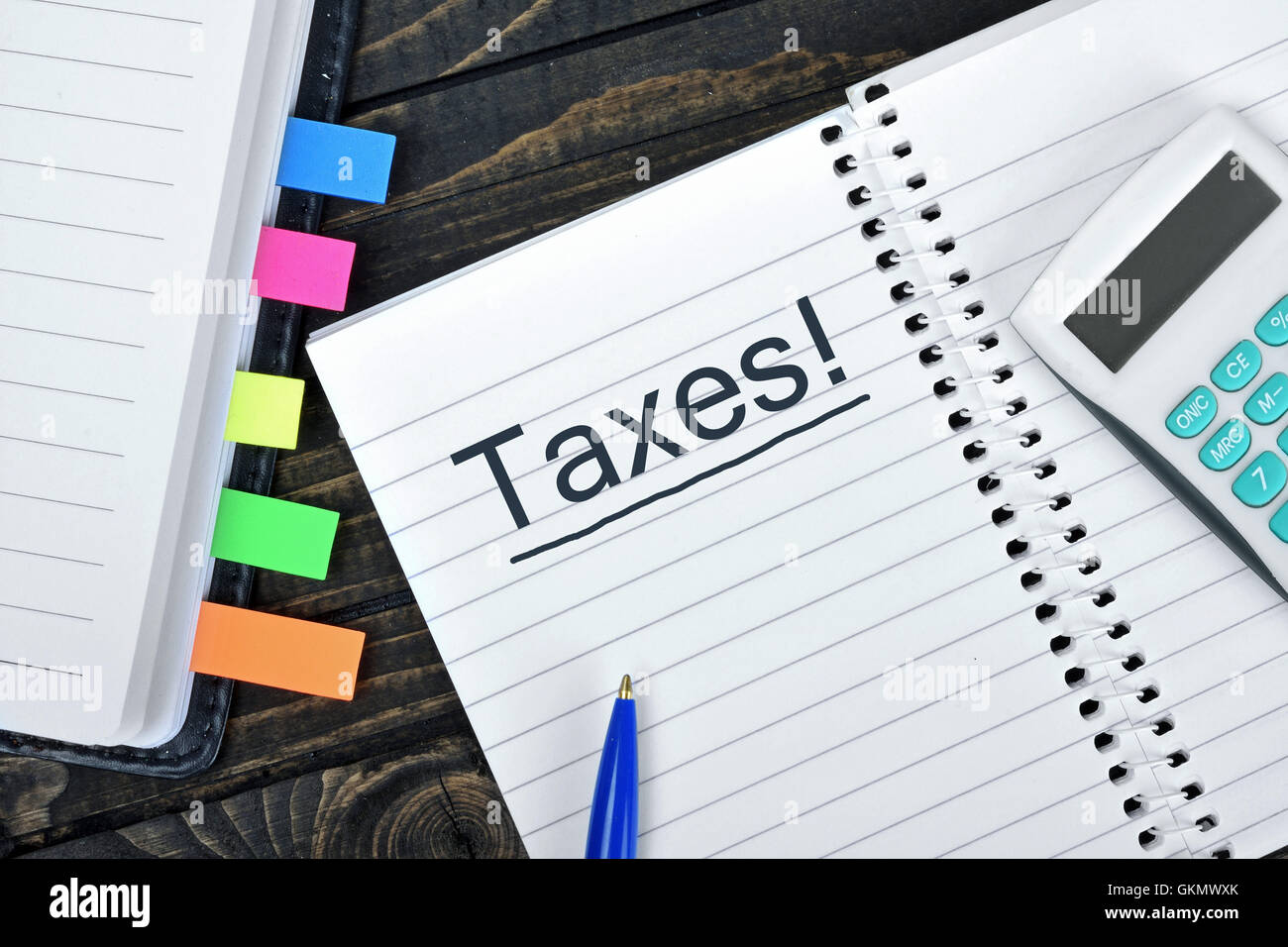 Taxes text on notepad and hand calculator Stock Photo - Alamy