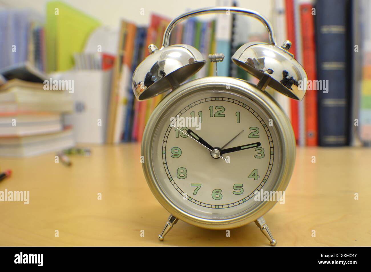 alarm clock on study desk Stock Photo - Alamy
