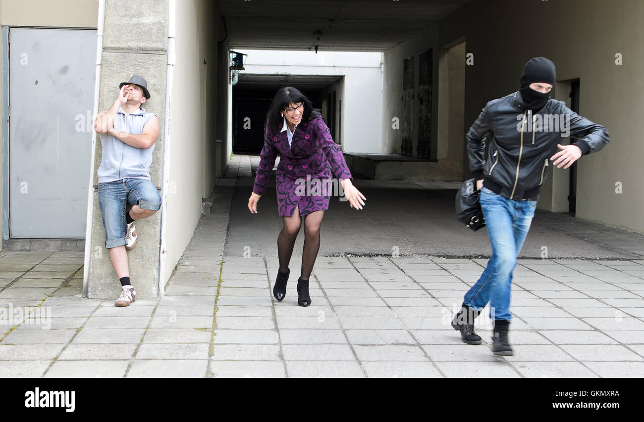 Daylight robbery on the street. Thief steals a bag Stock Photo - Alamy