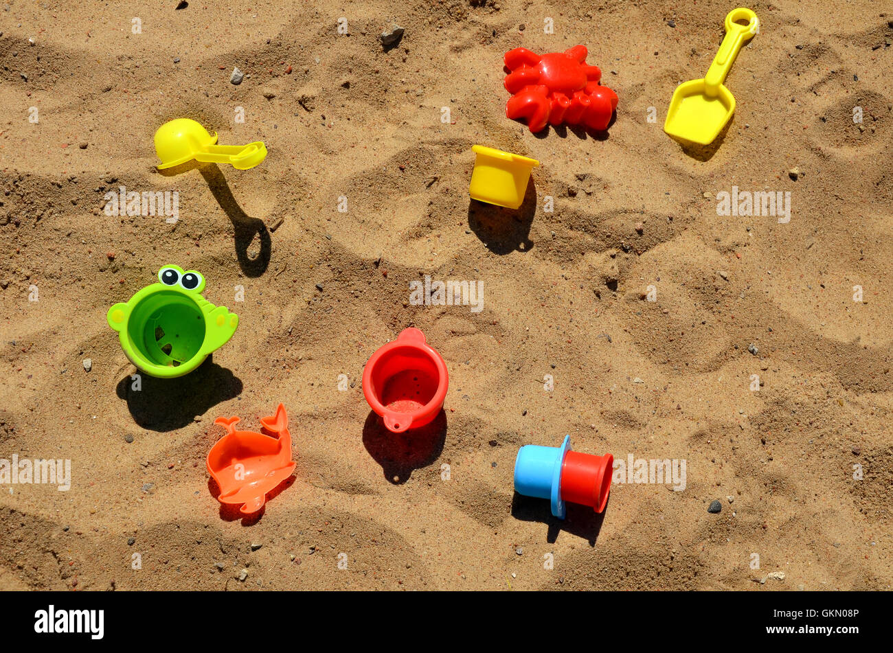 Various children's toys on the sand Stock Photo - Alamy